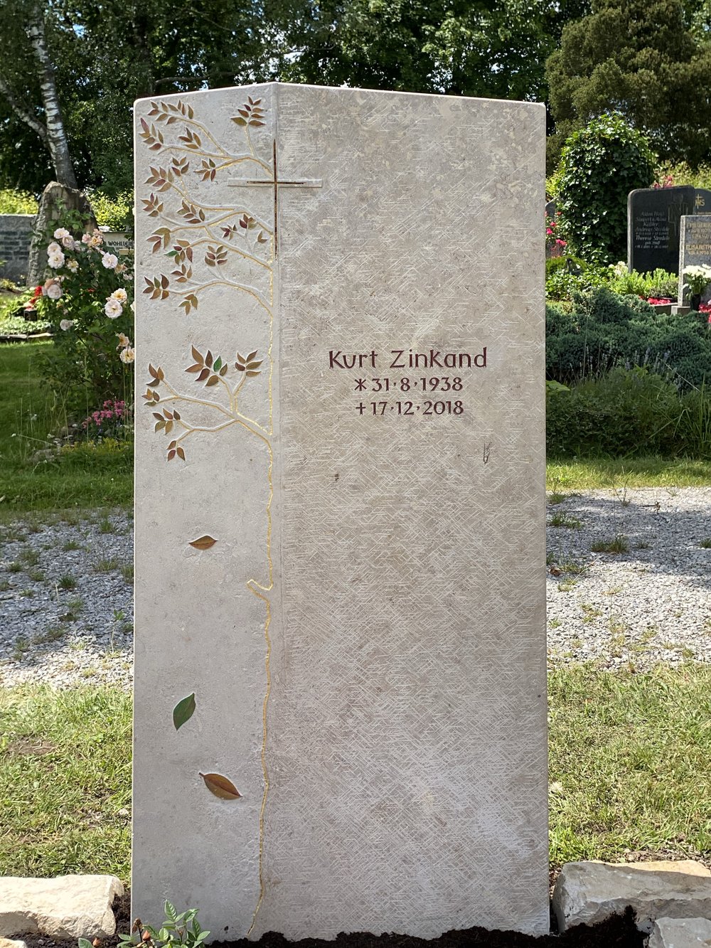 Schöner heller Grabstein mit Baum, Blätter und Kreuz